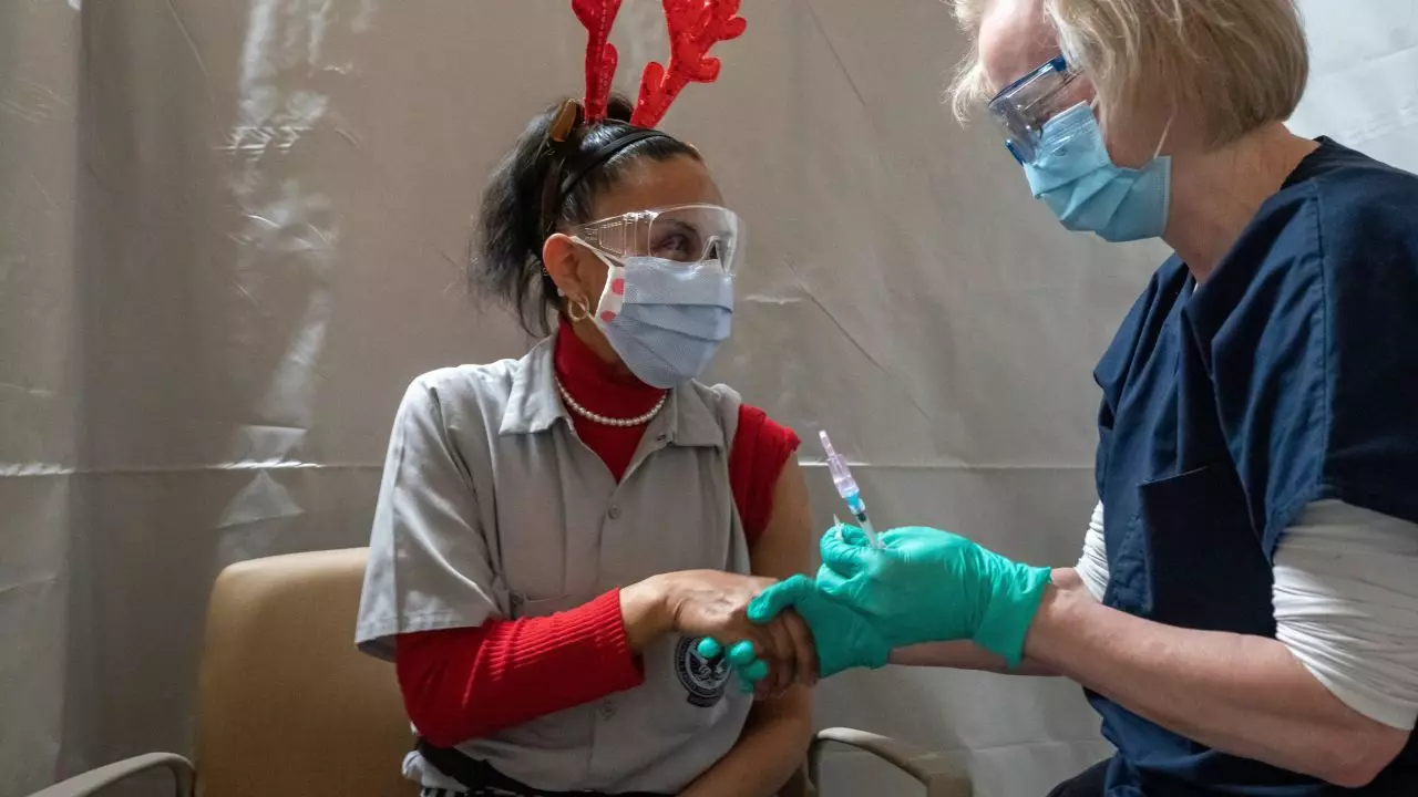 波特兰退伍军人事务医疗中心的管家 Marlena Right（左）感谢一名护士于 2020 年 12 月 16 日在俄勒冈州波特兰市接种了 covid-19。