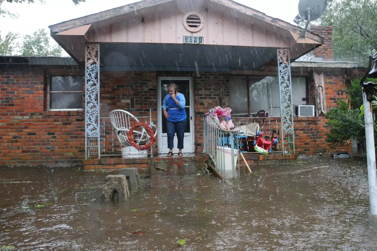 Une femme parle dans un téléphone portable pour demander de l'aide dans sa résidence inondée à Lumberton, en Caroline du Nord, le 15 septembre 2018 à la suite de l'ouragan Florence.