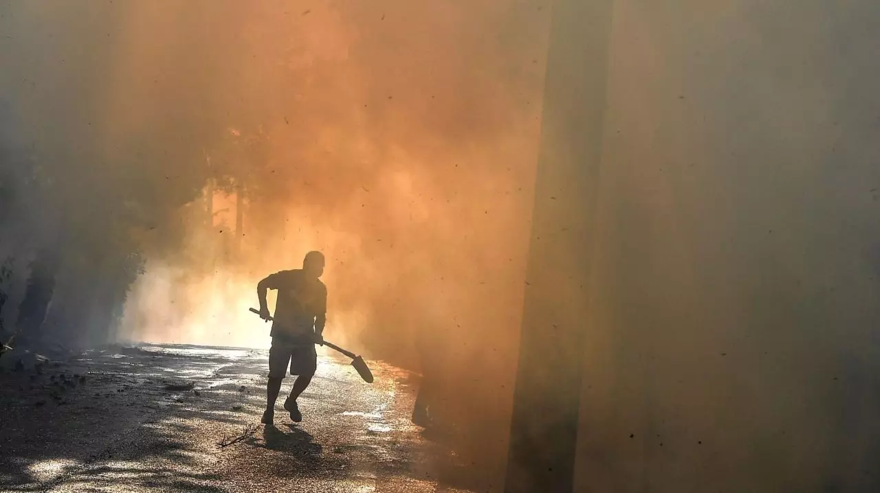 지역 주민이 2021년 8월 7일 그리스 아테네 북쪽 파르니타 산 근처 트라코마케도네스에서 화재를 진압하기 위해 달려갑니다.