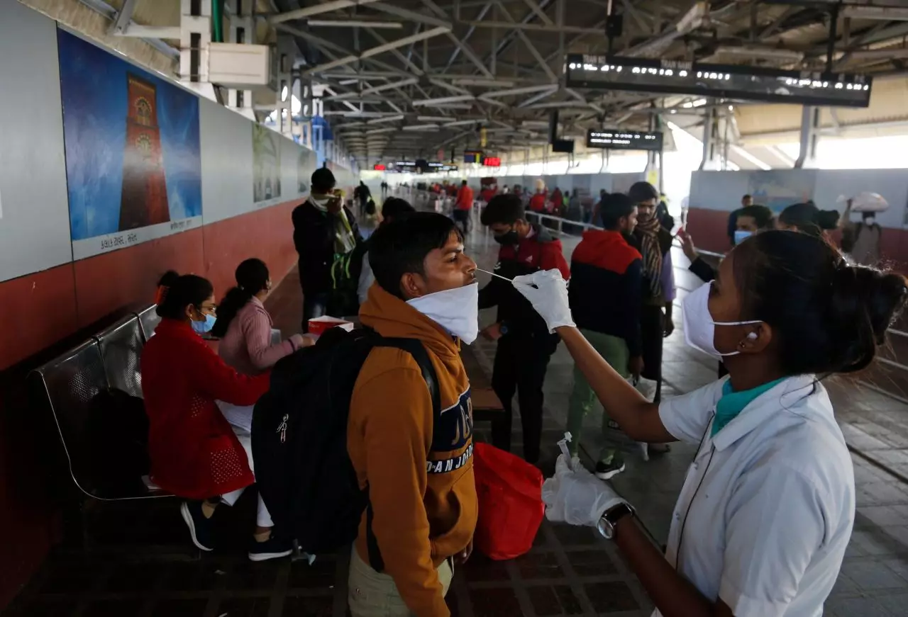 Здравствени радник узима брис путника који улази у град да тестира на ЦОВИД-19 на железничкој станици у Ахмедабаду, Индија, у петак, 3. децембра 2021. Индија је у четвртак потврдила прве случајеве омикронске варијанте коронавируса у две људи и званичници су рекли да је један стигао из Јужне Африке, а да други није имао историју путовања. Врхунски медицински стручњак је позвао људе да се вакцинишу.