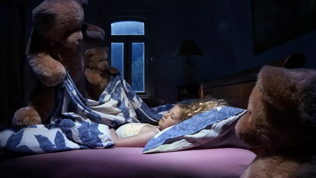 стоцк имаге Плишани медведи који увлаче девојчицу у кревет