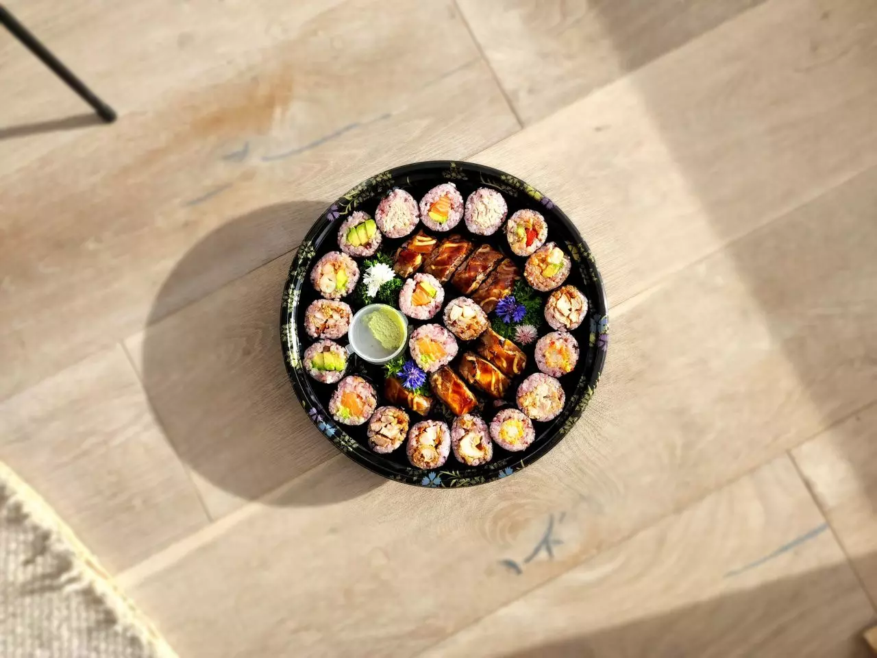 Un platou mare de sushi pe o podea de lemn
