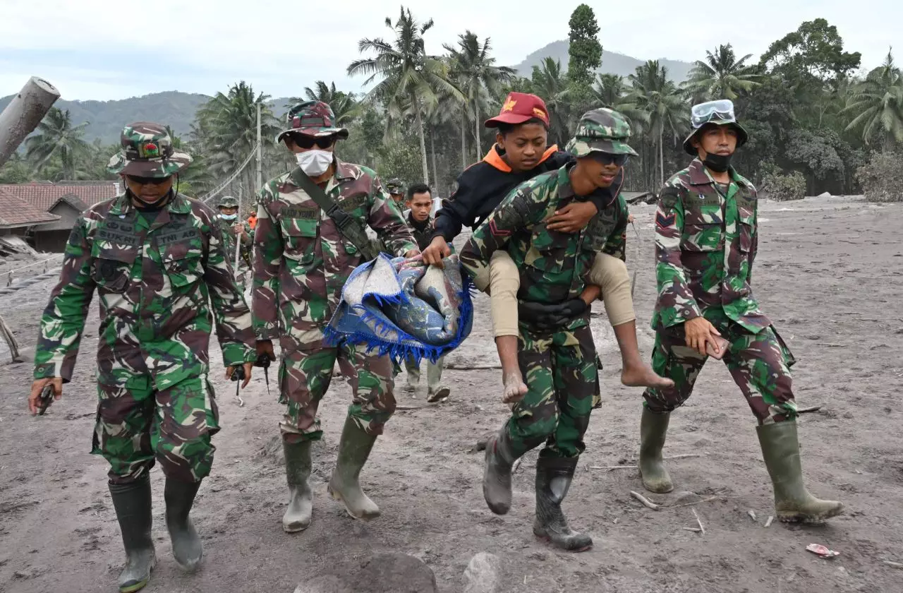 Los miembros de un equipo de búsqueda y rescate cargan a un aldeano durante una operación en el pueblo de Sumberwuluh.